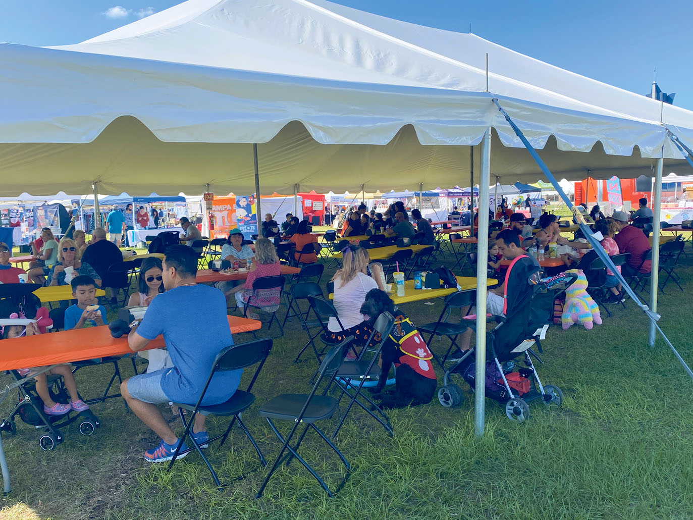 Fall-Fest-People-Eating-Under-Tent — Neighborhood News